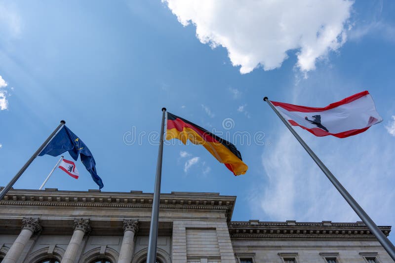 Three Flags are Flying High in the Sky, One of Which is a Red Stock ...