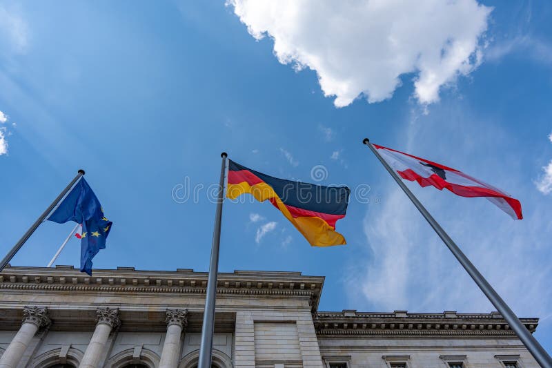 Three Flags are Flying on Poles Outside a Building Stock Image - Image ...