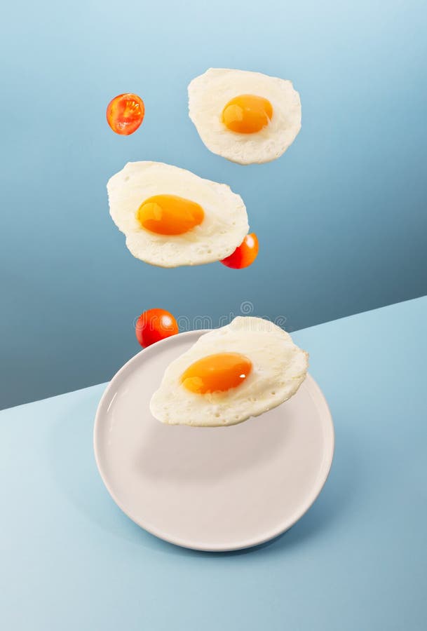 Three Flying Eggs and a Plate on the Modern Blue Background Stock Photo ...