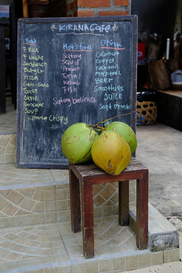 Three Coconuts on Wooden Stool with Chalkboard Menu in Background Stock ...