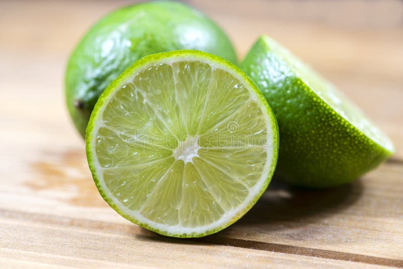 Three Fresh LImes, Bright and Green, on a Cutting Board Stock Photo ...