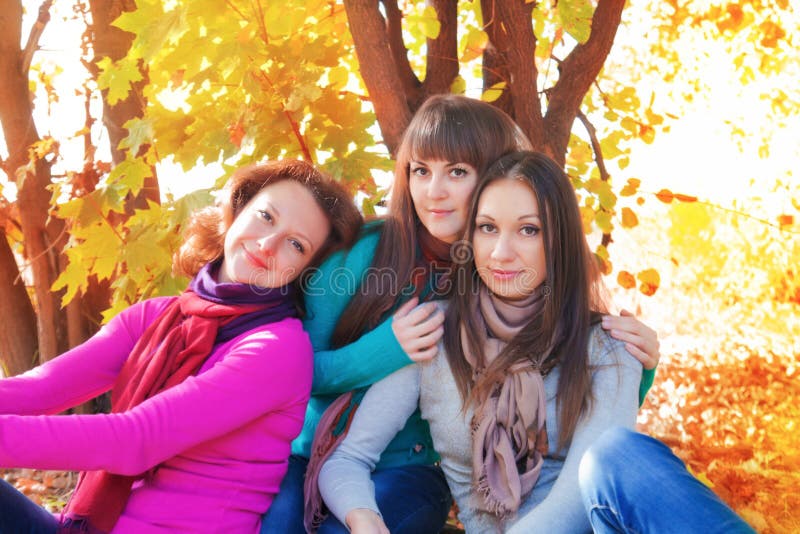 Three Friends on the Background of Autumn Leaves Stock Image - Image of ...