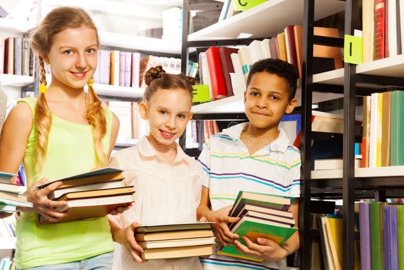 Three Friends with Books Standing Near Bookshelf Stock Photo - Image of ...