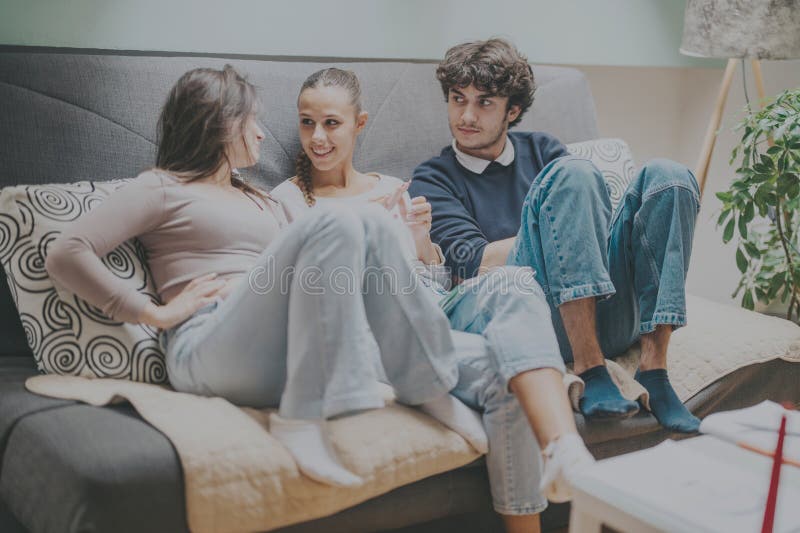 Three Friends Casually Talking and Relaxing on a Cozy Sofa Stock Photo ...