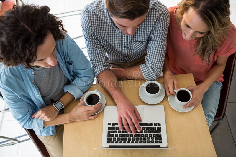 Three Friends with Coffee Cups Using a Laptop Stock Image - Image of ...