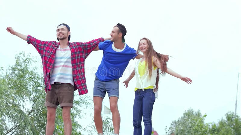 Three Friends Joyfully Flapping Their Arms while Standing on Rocks by ...
