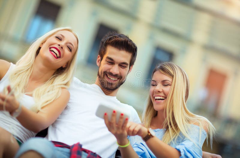 Three Friends Sitting on a Bench and Looking the Phone Stock Image ...