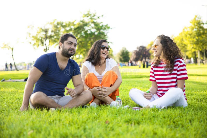 Three Friends Sitting on the Grass in the Park Stock Image - Image of ...