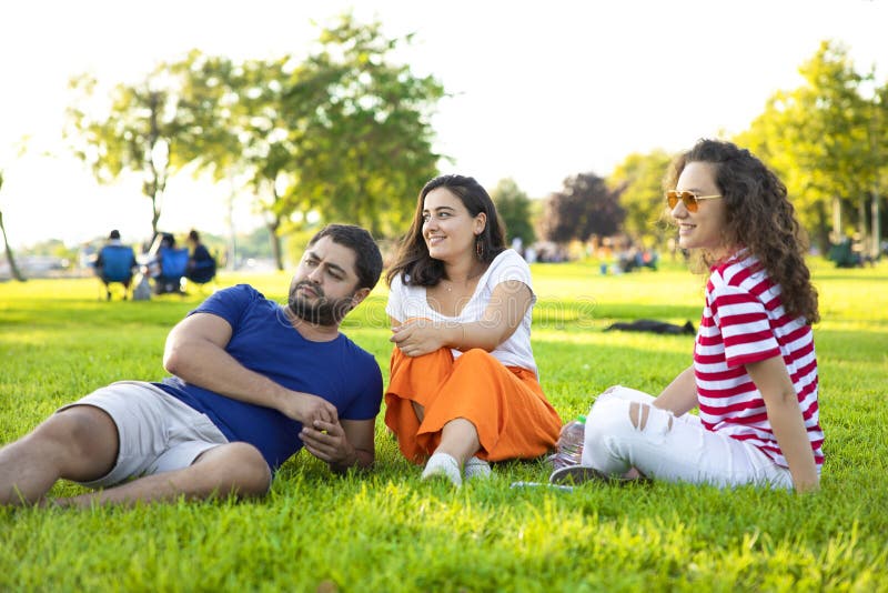 Three Friends Sitting on the Grass in the Park Stock Image - Image of ...