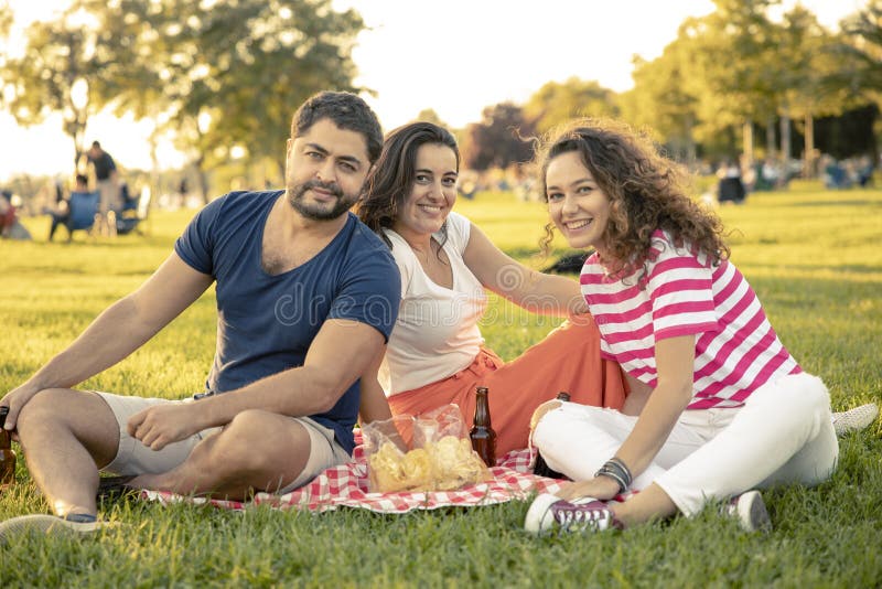 Three Friends Sitting on the Grass in the Park Stock Photo - Image of ...