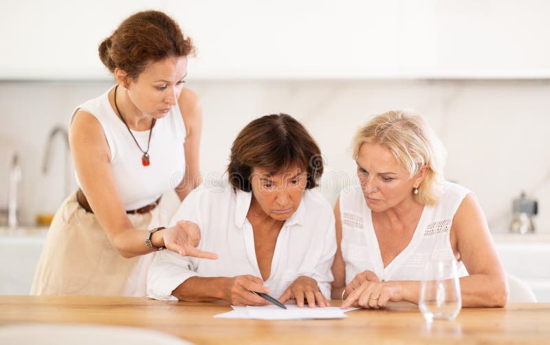Three Friends Try To Solve Financial Problems Together by Discussing Documents in Kitchen of ...