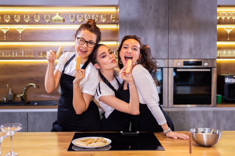 Three Funny Female Chef in Uniform Holding Cookies while Smiling and ...