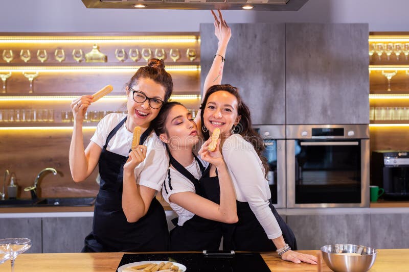 Three Funny Female Chef in Uniform Holding Cookies while Smiling and ...