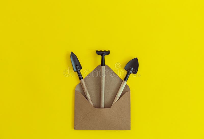 Three Garden Tools in a Craft Envelope and Cardboard Glasses on Yellow ...