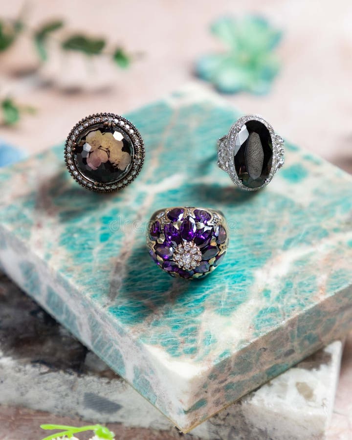 Three Gemstone Rings Sparkling on Green Marble Slab Stock Image - Image ...