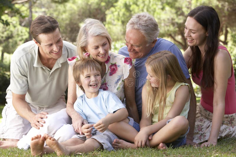 Three Generation Family Sitting in Park Together Stock Photo - Image of ...