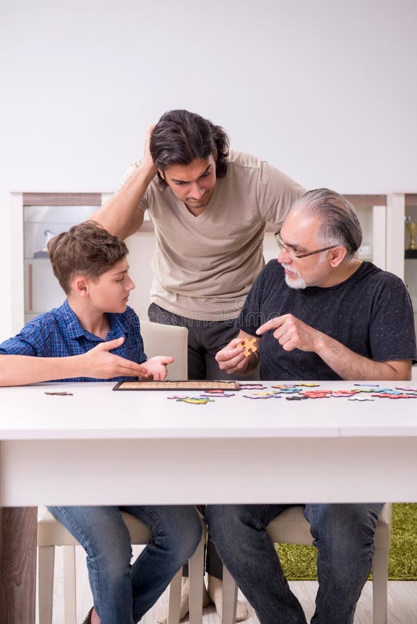 Three Generations Of Family Playing Jigsaw Puzzle Game Stock Photo ...