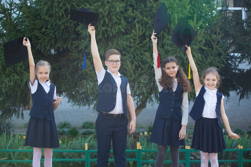 Three Girls and a Boy are Elementary School Graduates in a Graduate Hat ...