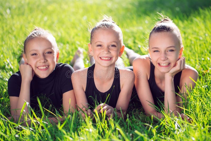 Three Girls Lying in the Grass and Having Fun. Stock Image - Image of ...