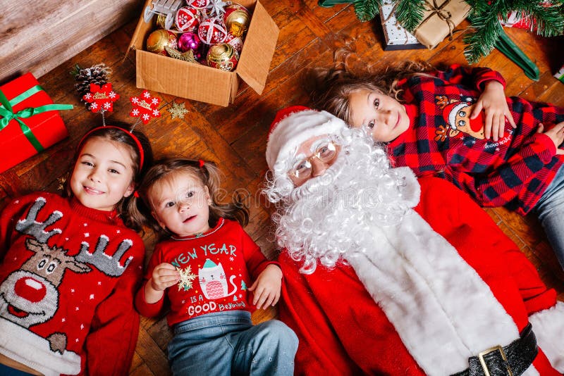 Three Girls and Santa Lie on the Floor at Home Near Christmas Tree ... Three Girls and Santa Lie on the Floor at Home Near Christmas Tree ...