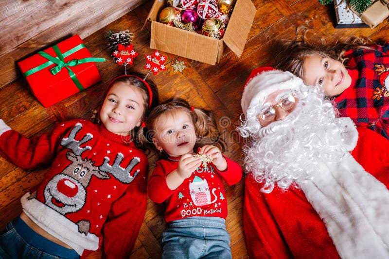 Three Girls and Santa Lie on the Floor at Home Near Christmas Tree ... Three Girls and Santa Lie on the Floor at Home Near Christmas Tree ...