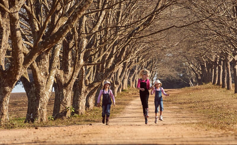 Three Girls Sisters Running Skipping Down Tree Lined Dirt Road Stock ...