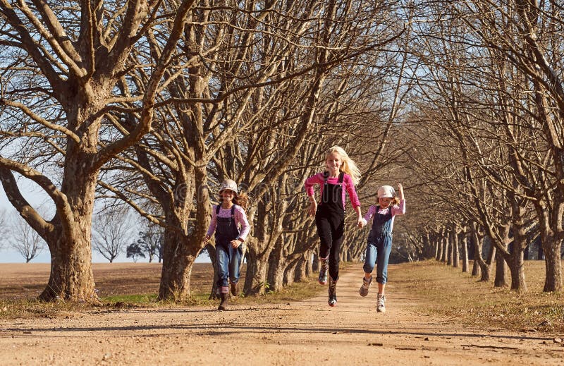Three Girls Sisters Running Skipping Down Tree Lined Dirt Road Stock ...