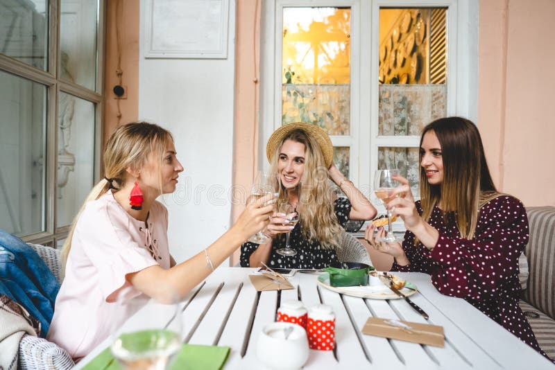 Three girls at the table stock photo. Image of camera - 139913042