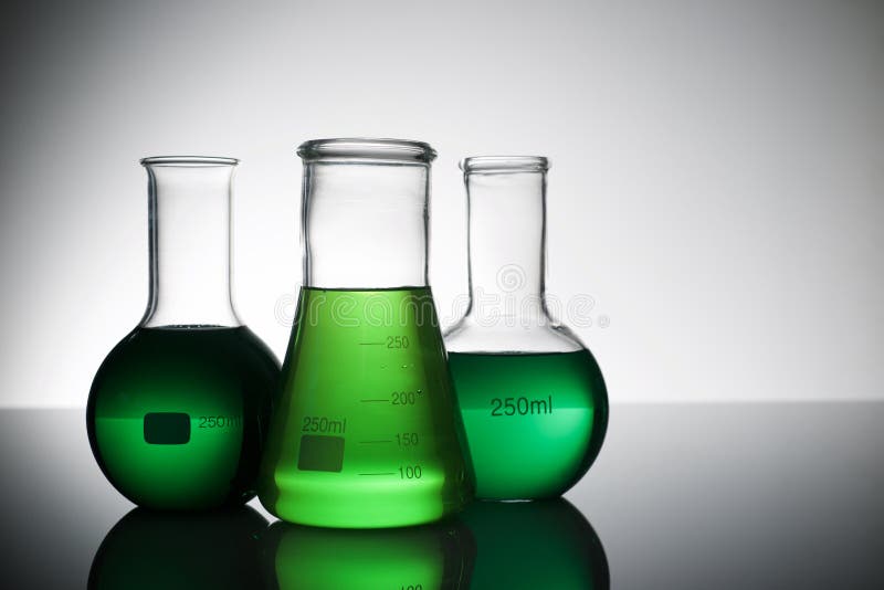 Three Glass Flask Placed in a Laboratory Table with Green Liquid Stock ...