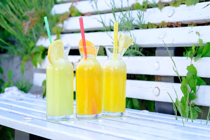 Refreshing Summer Drinks on a White Bench Garnished with Citrus Slices ...