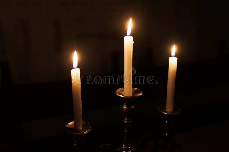Three Glowing Candles Burning in the Dark, Creating a Serene and ...