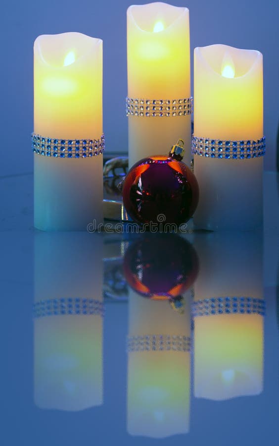Three Glowing Candles at Christmas with Mirror Image Below Stock Photo ...