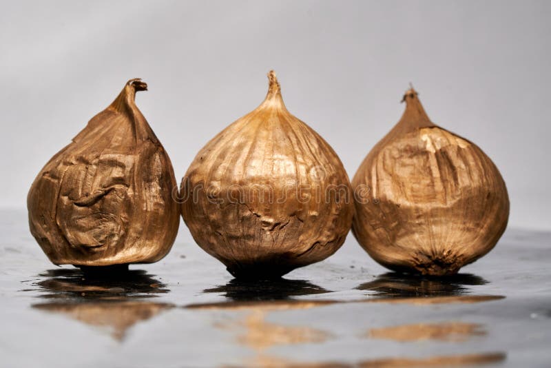 Three of Golden Garlic on Shiny Table Stock Image - Image of vegetarian ...