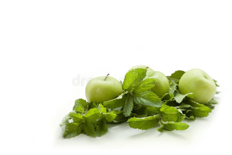 Three Green Apples Lie on Mint Leaves on a White Background with Copy ...