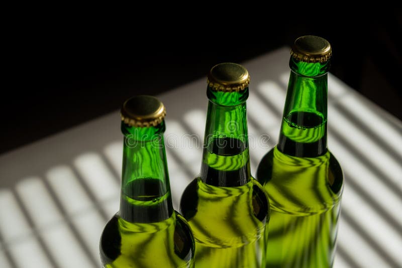 Three Green Glass Beer Bottles in the Shade of the Blinds. Stock Photo ...