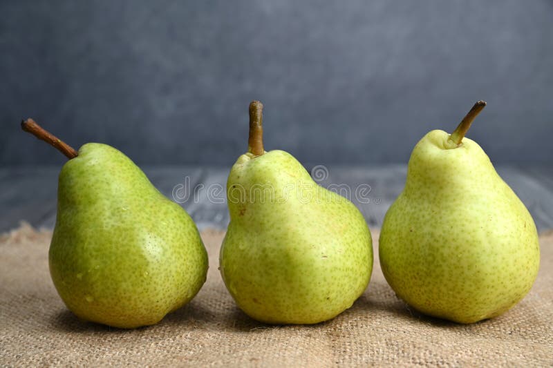 Three Green Pears of the Same Sort are Standing Next To Each Other on ...
