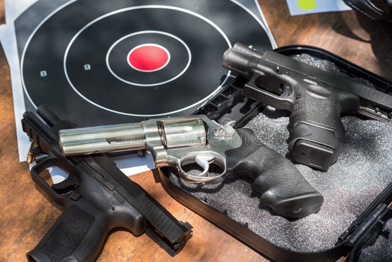 Three Guns and Target on Table Outside Stock Photo - Image of policies ...