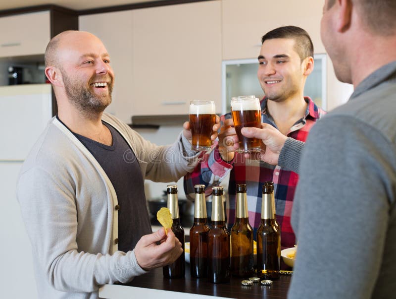 Three guys at house party stock image. Image of indoor - 60762685