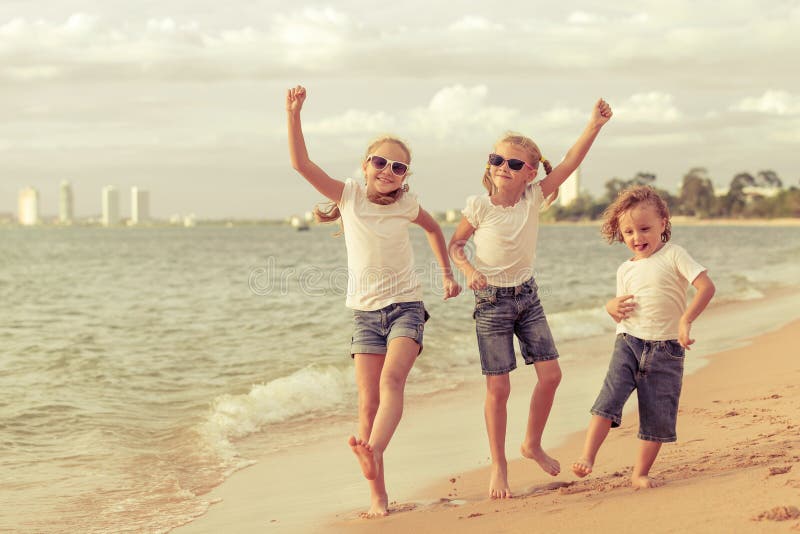 Three Happy Children Dancing on the Beach Stock Photo - Image of ...