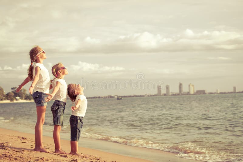 Three Children Standing on the Beach Stock Photo - Image of girl ...