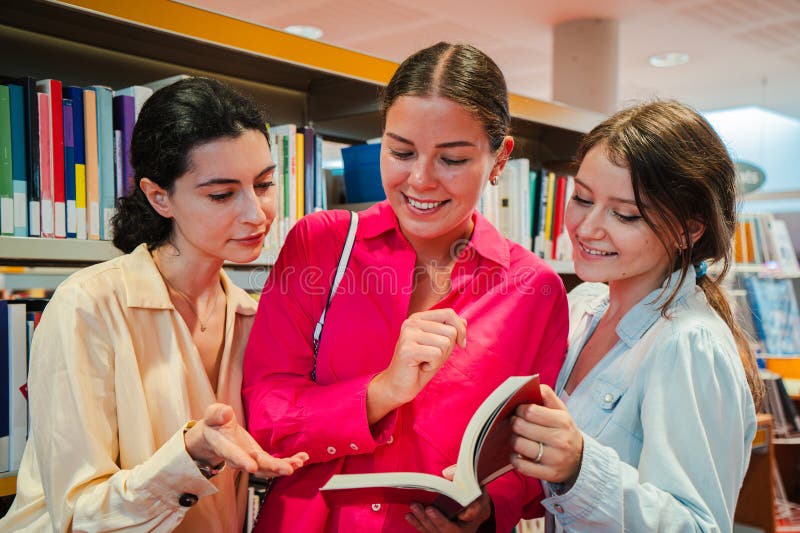 Three Happy Female University Students Reading and Studying Together ...