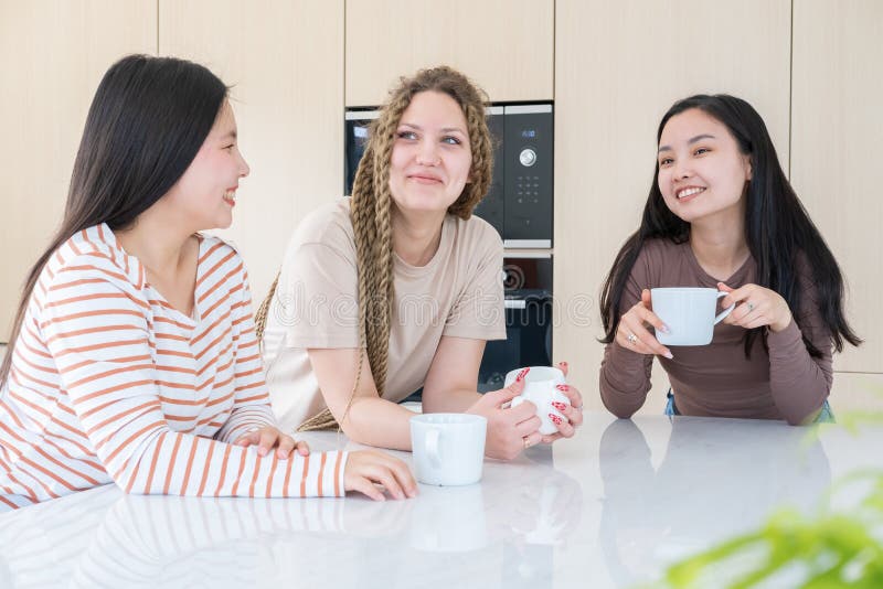 Three Happy Young Diversity Girlfriends Drinking Tea, Talking, Having ...