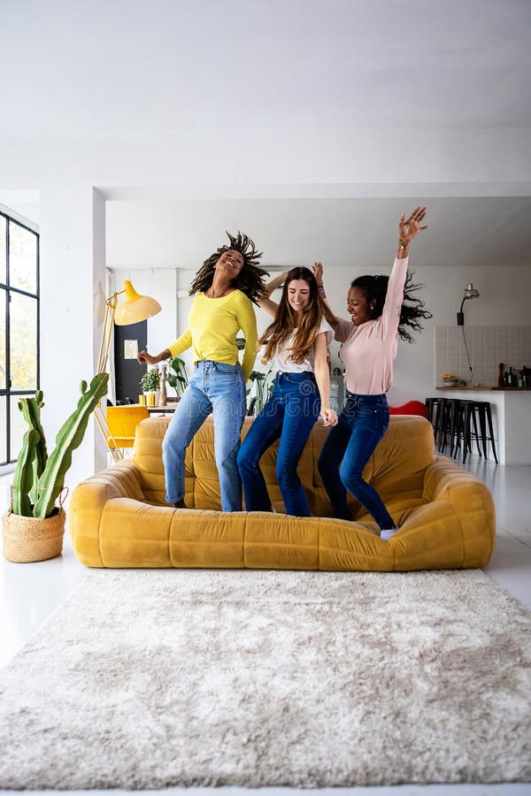 Three Happy Young Girls Dancing on Sofa at Home Stock Image - Image of ...