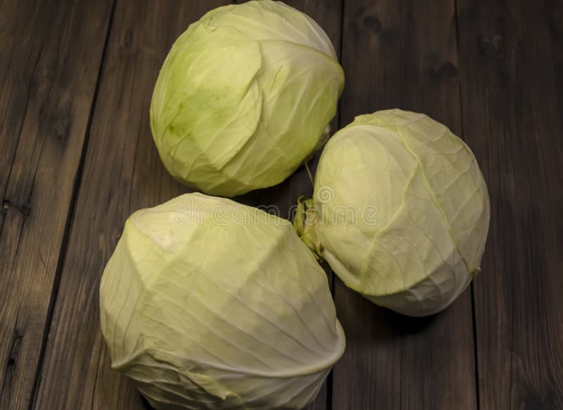 Three Heads of Cabbage on a Wooden Table. Three Heads of Cabbage ...