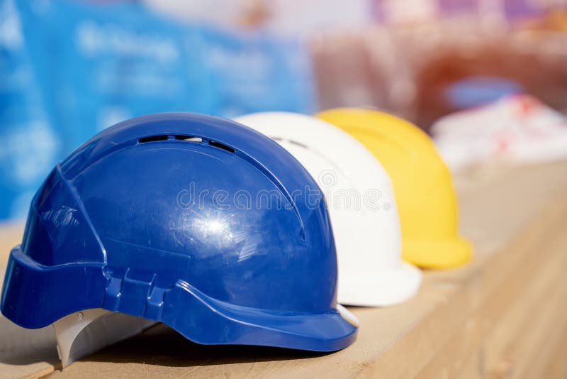 Three Helmets of Different Colors on Top of Timber Board Close-up with ...