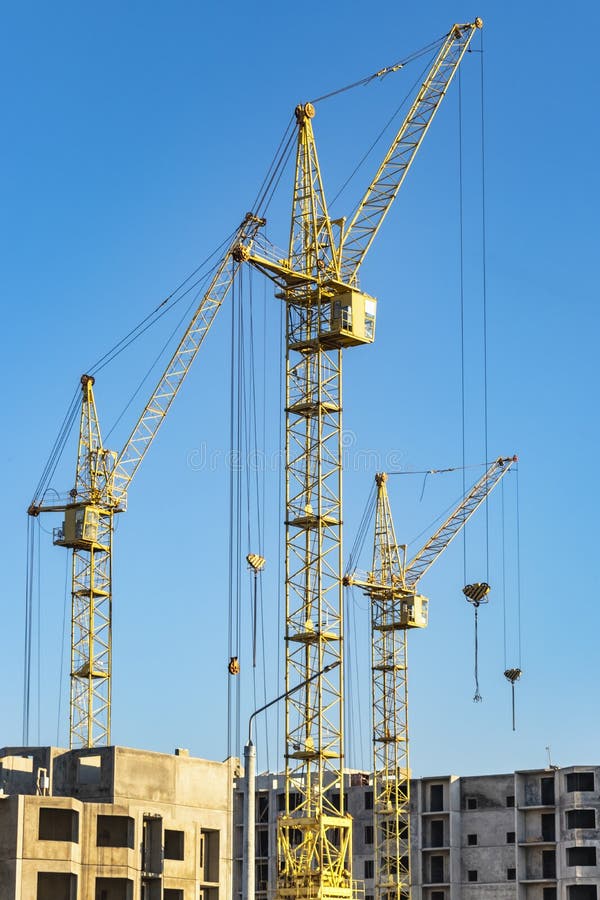 Three High Construction Tower Cranes Against the Blue Sky. Construction ...
