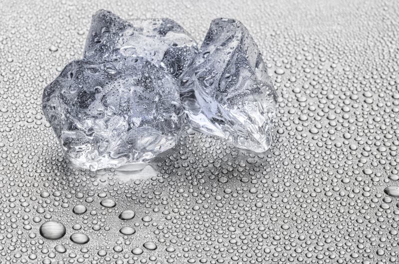 Three Ice Cubes on a Metallic Surface with Water Drops Stock Image ...