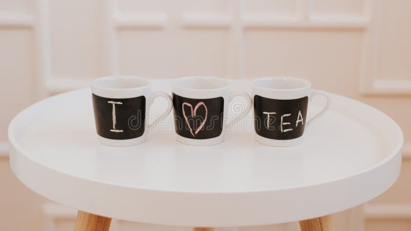 Three Identical Small Cups in a Row Standing on White Round Wooden ...