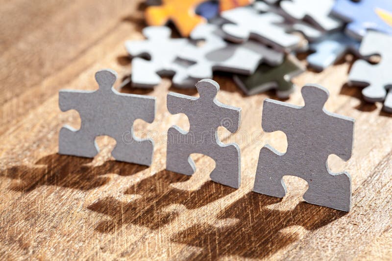 Three Jigsaw Puzzle Pieces on Table Lit by Back Light Stock Image ...