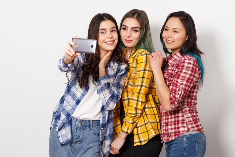 Three Joyful Girls Girlfriends Are Doing Selfie Smiling On White